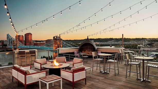Terraço no telhado com área de estar ao ar livre, lareira e luzes de fada.