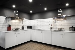 Uma cafeteira/bule, um frigorífico no espaço comum