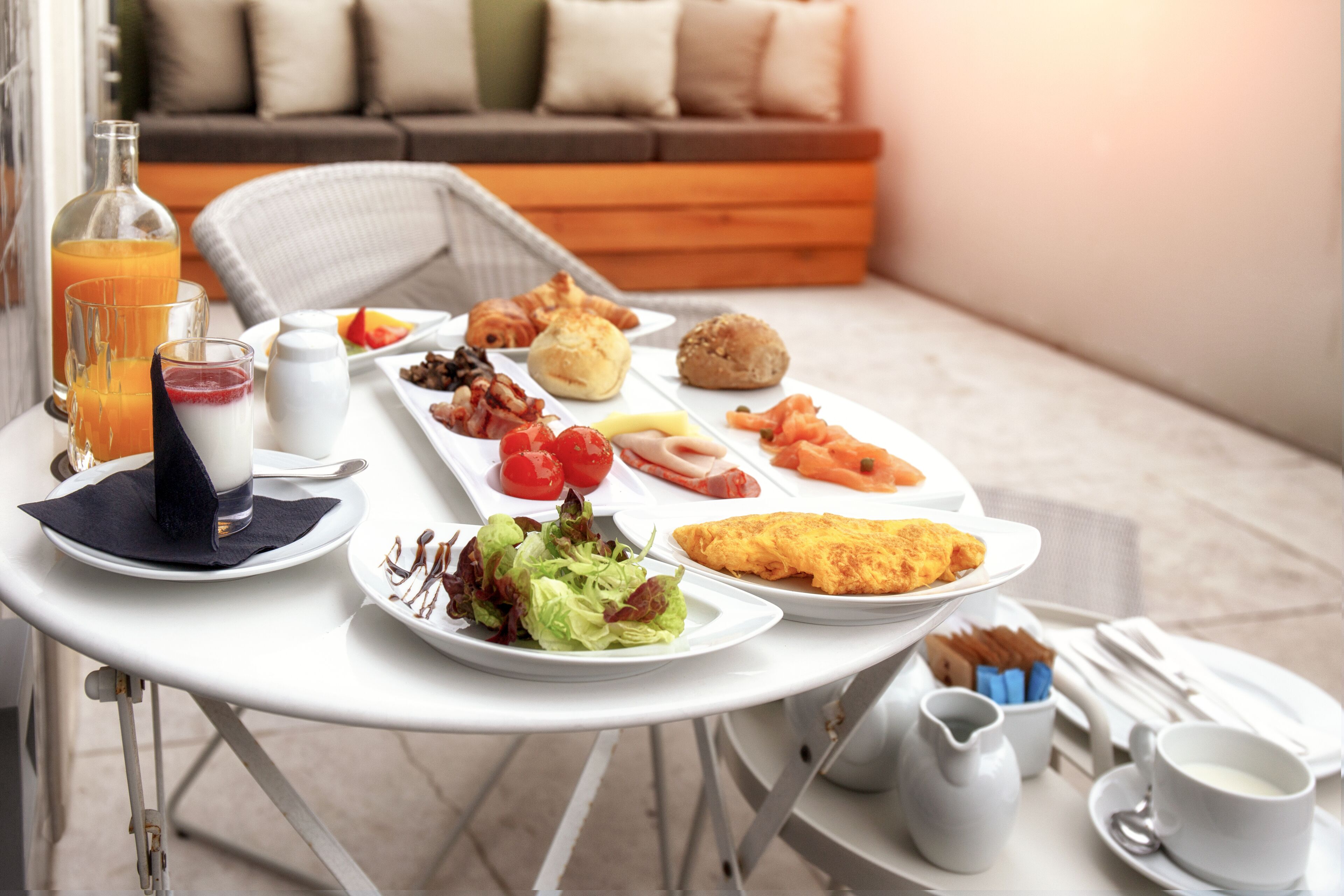 Uma mesa de café da manhã com diversos alimentos e uma garrafa de suco de laranja.
