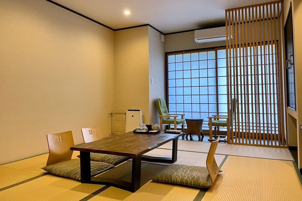 Um quarto em estilo japonês tradicional, com tatames, uma mesa baixa e painéis shoji.
