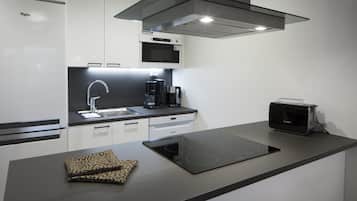 Um frigorífico, um micro-ondas, um forno, uma placa de cozinha