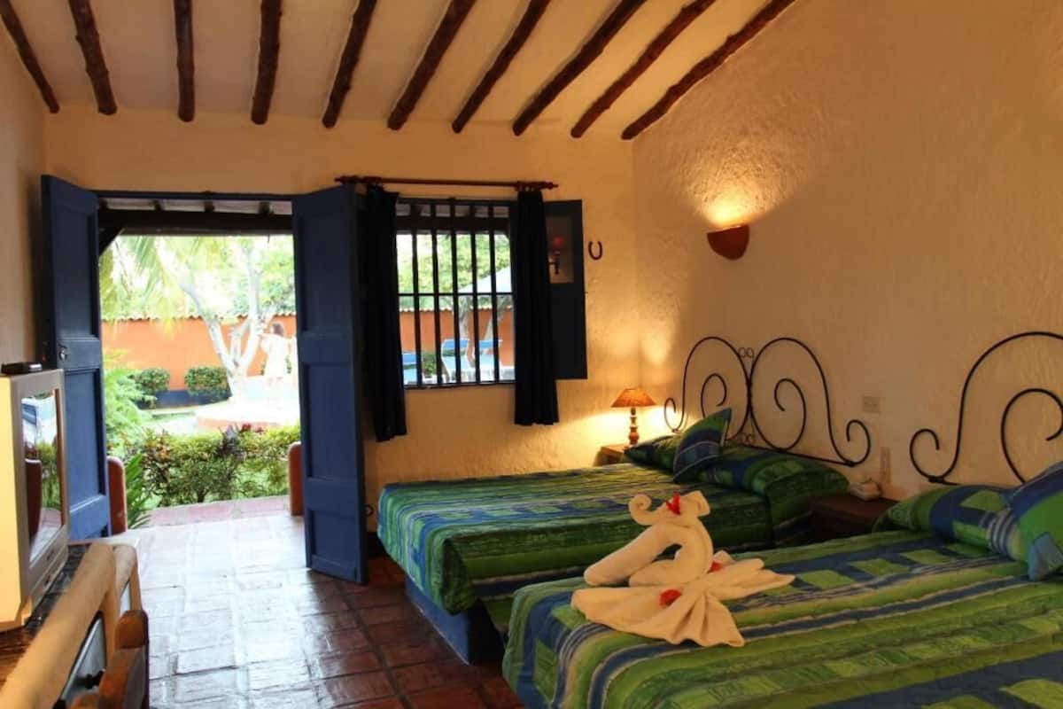 Quarto Quádruplo Standard, vista para a piscina | Edredões de penas, cofre no quarto, secretária, ferro/tábua de engomar