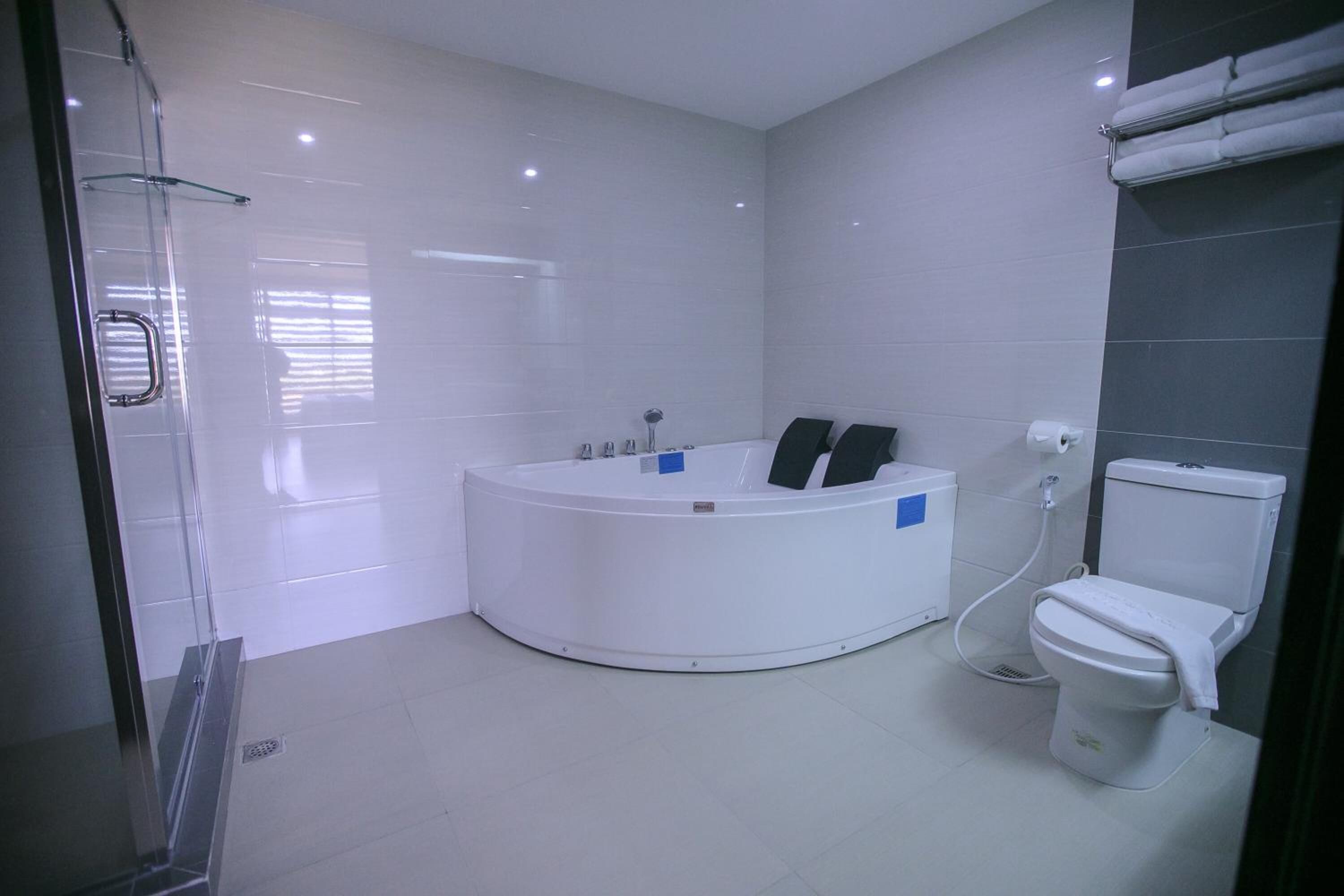 Uma casa de banho moderna com banheira, sanita e cabine de duche em vidro.