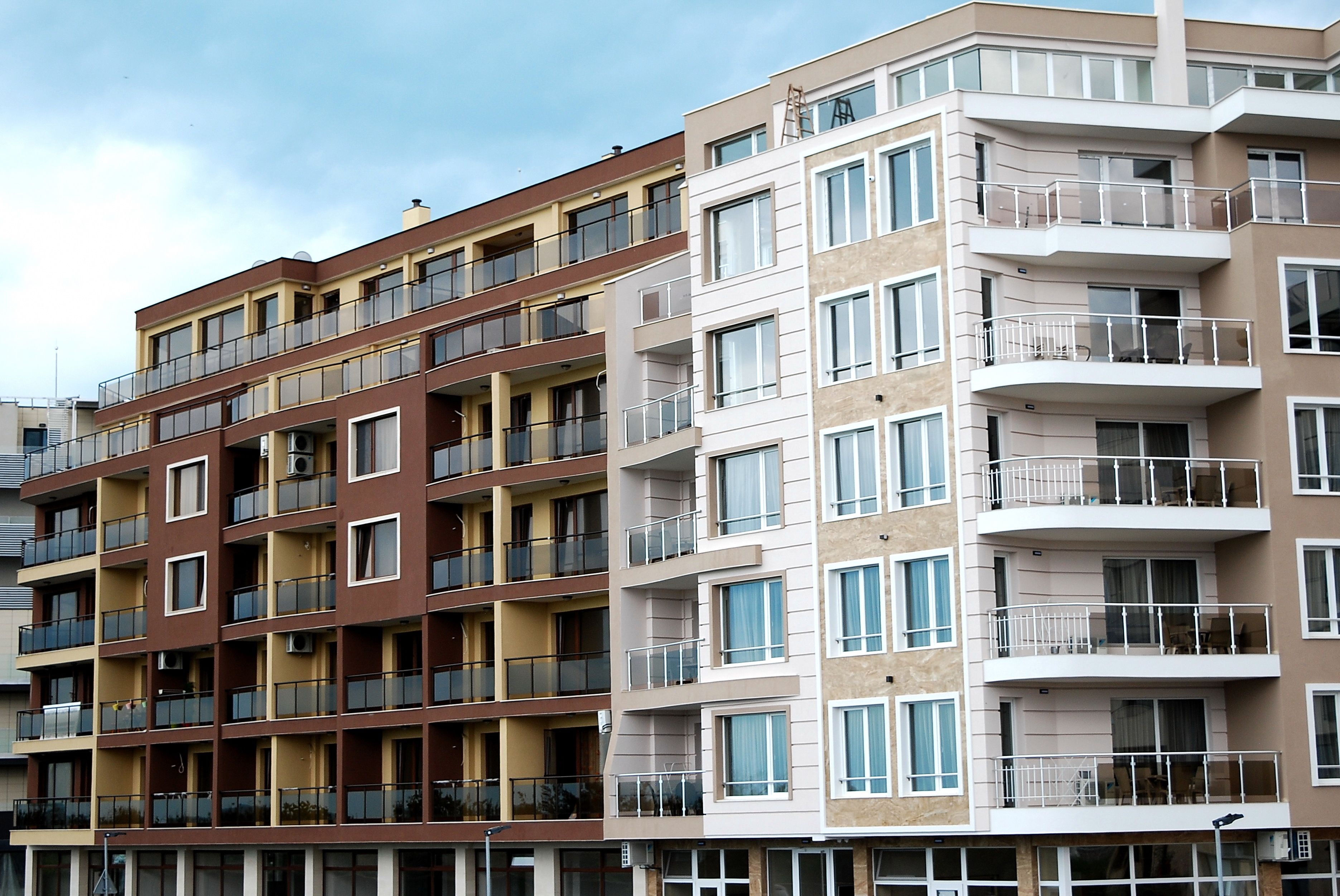 Um edifício residencial com várias andares, varandas, janelas amplas e um design arquitetônico moderno.