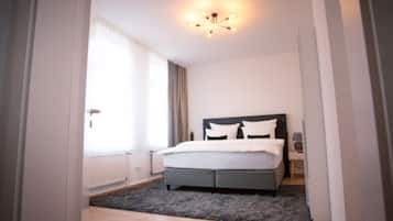 Quarto moderno com cama grande, mesa de cabeceira, luminária e luminária de teto.