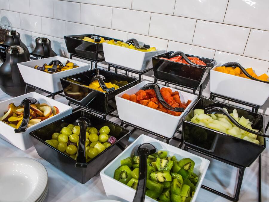 Buffet com diversas opções de frutas e legumes.