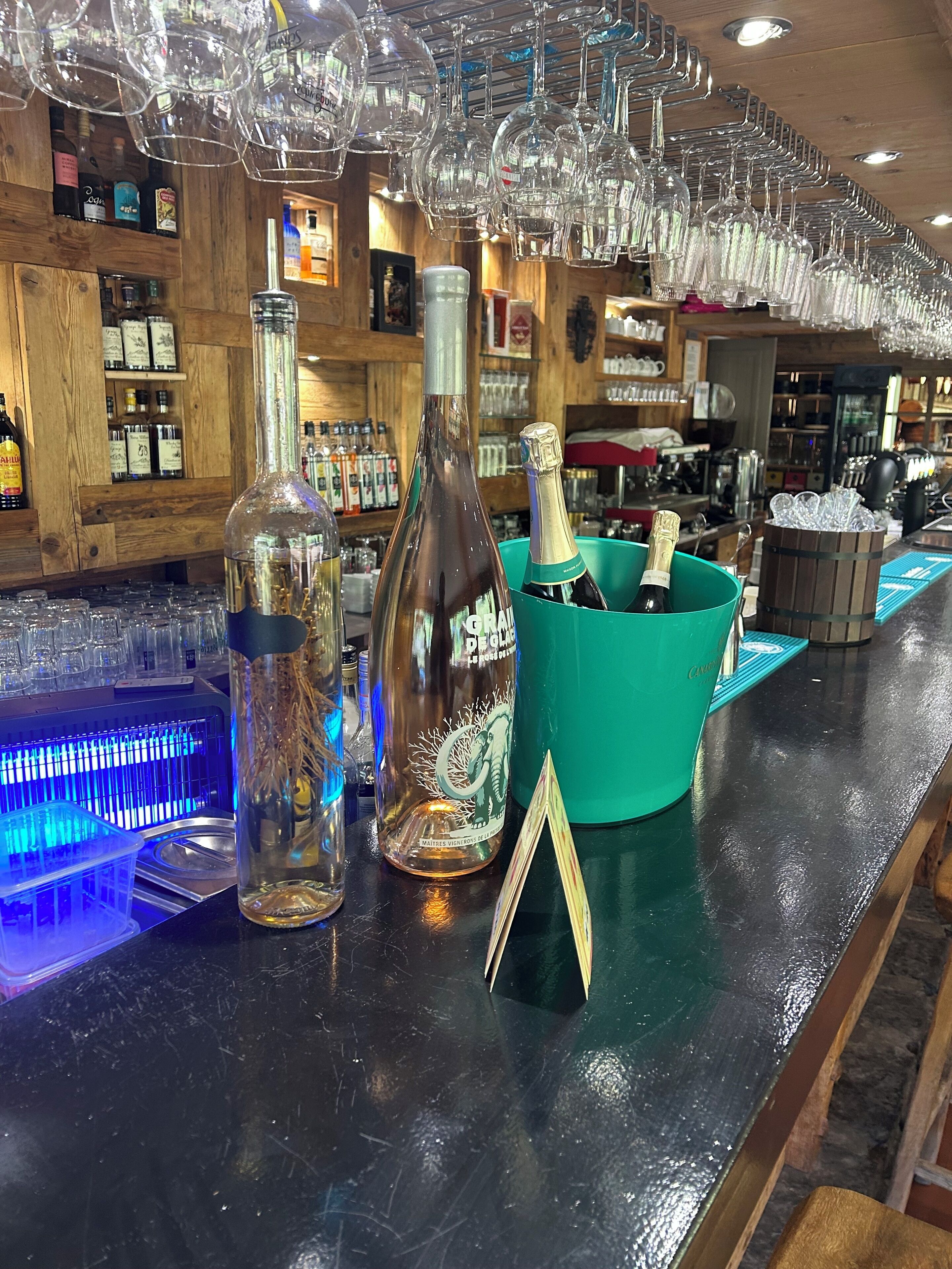 Uma área de bar com diversos frascos e copos.