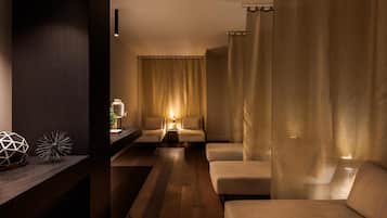 Quarto moderno com sofá, uma mesinha de canto com luminária e objeto decorativo.