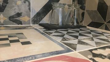 Cozinha com painel de azulejos quadriculados e bancada preta.