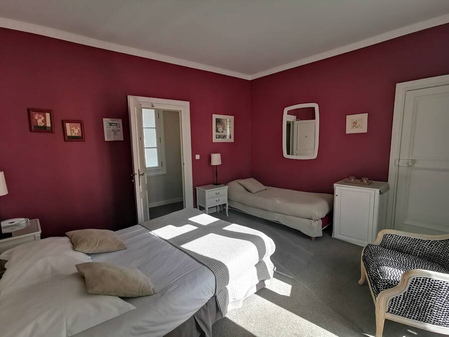Quarto com duas camas, uma escrivaninha, uma cadeira e um guarda-roupa.