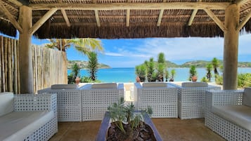 Na praia, espreguiçadeiras, guarda-sóis, toalhas de praia