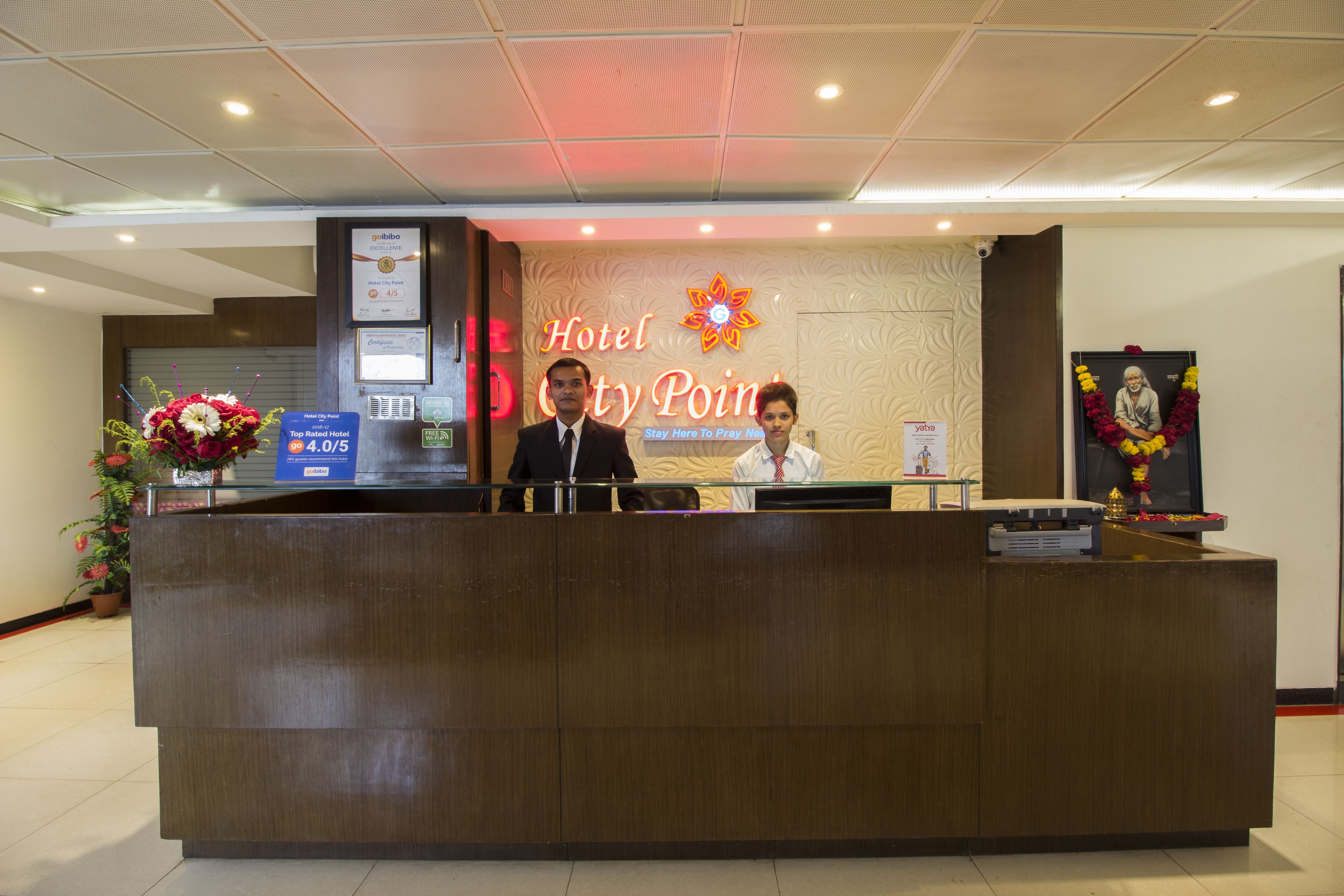 Bancada de recepção de hotel com uma placa indicando "Hotel City Point".