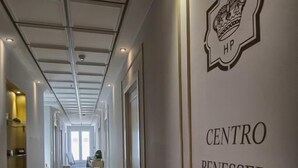 Um corredor com piso de madeira, uma placa com a inscrição 'CENTRO BENESSERE' e um logotipo com 'HP' em destaque.