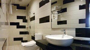 Casa de banho moderna com bancada preta, lavatório branco e sanita.
