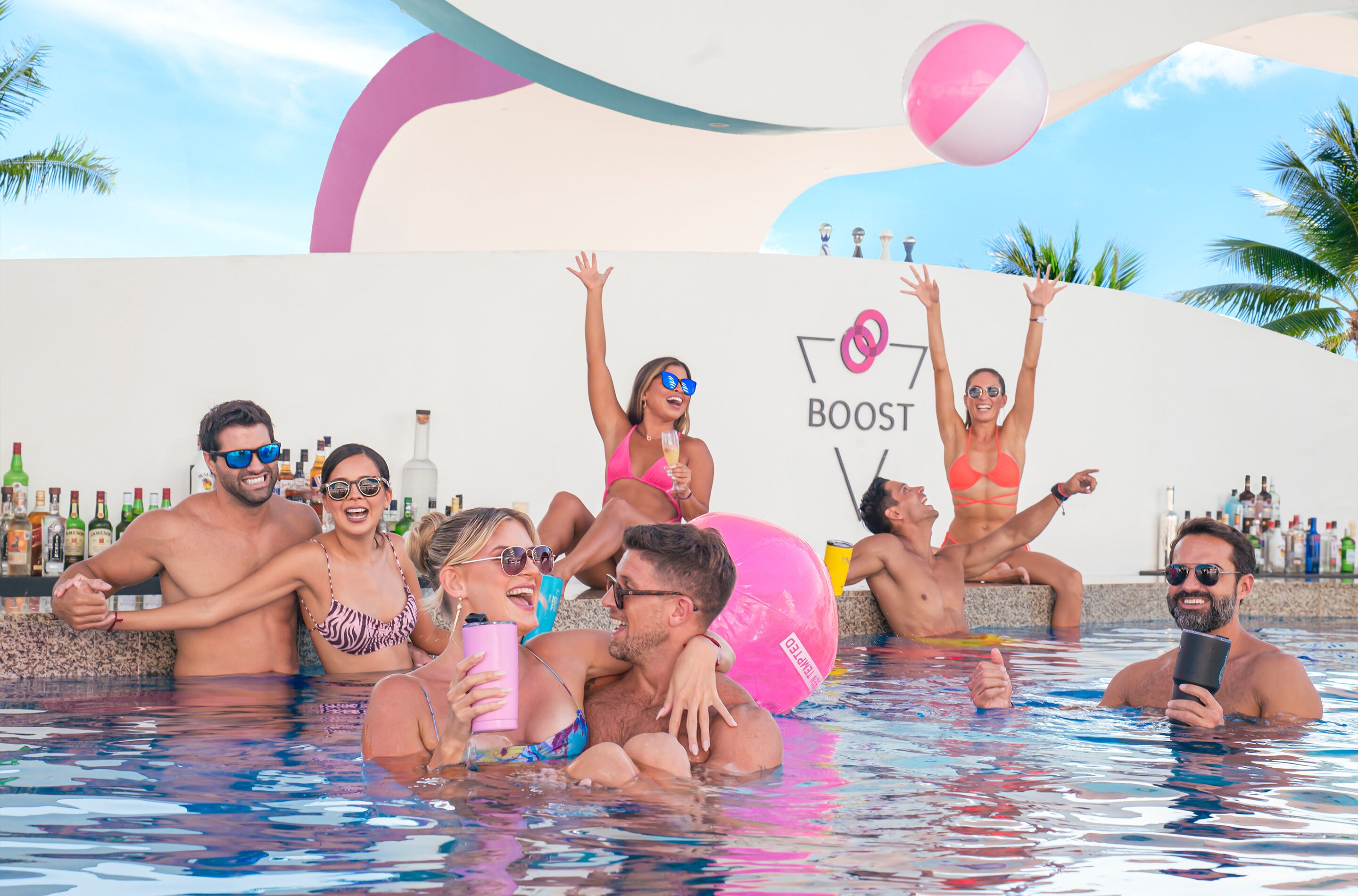 Um grupo de pessoas em uma piscina, com um letreiro 'BOOST' ao fundo.