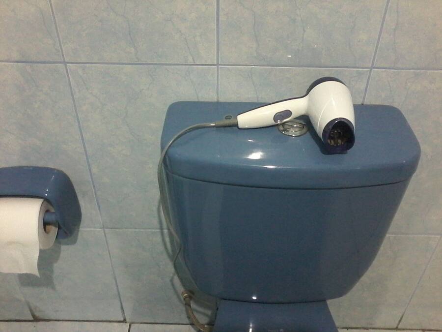 Casa de banho com sanita e dispensador de papel.