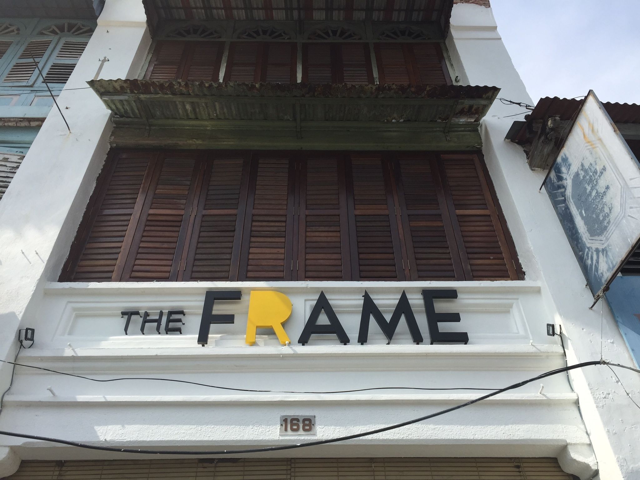 Fachada de edifício com uma placa indicando 'THE FRAME' e o número 168.