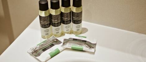 Quatro garrafas de shampoo Porto Douru e dois sachês de produtos para cabelo sobre uma superfície branca.