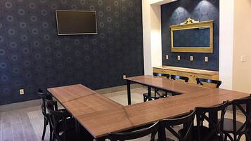 Uma sala de conferências com parede de padrão escuro, uma mesa grande e várias cadeiras.