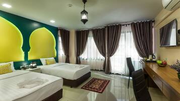 Quarto de hotel com duas camas, uma escrivaninha, televisão e uma janela grande com cortinas.