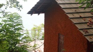 Um edifício com fachada vermelha e telhado inclinado.