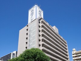 Um hotel com uma torre do relógio imponente, vários andares e um design arquitetônico moderno.