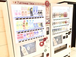 Duas máquinas de venda automática com diversas opções de bebidas e lanches.