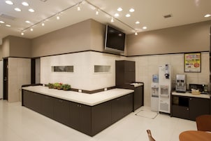 Uma cozinha moderna com uma ilha central, eletrodomésticos embutidos e uma TV de tela plana.