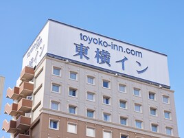 Um edifício com uma placa indicando toyoko-inn.com e caracteres japoneses.