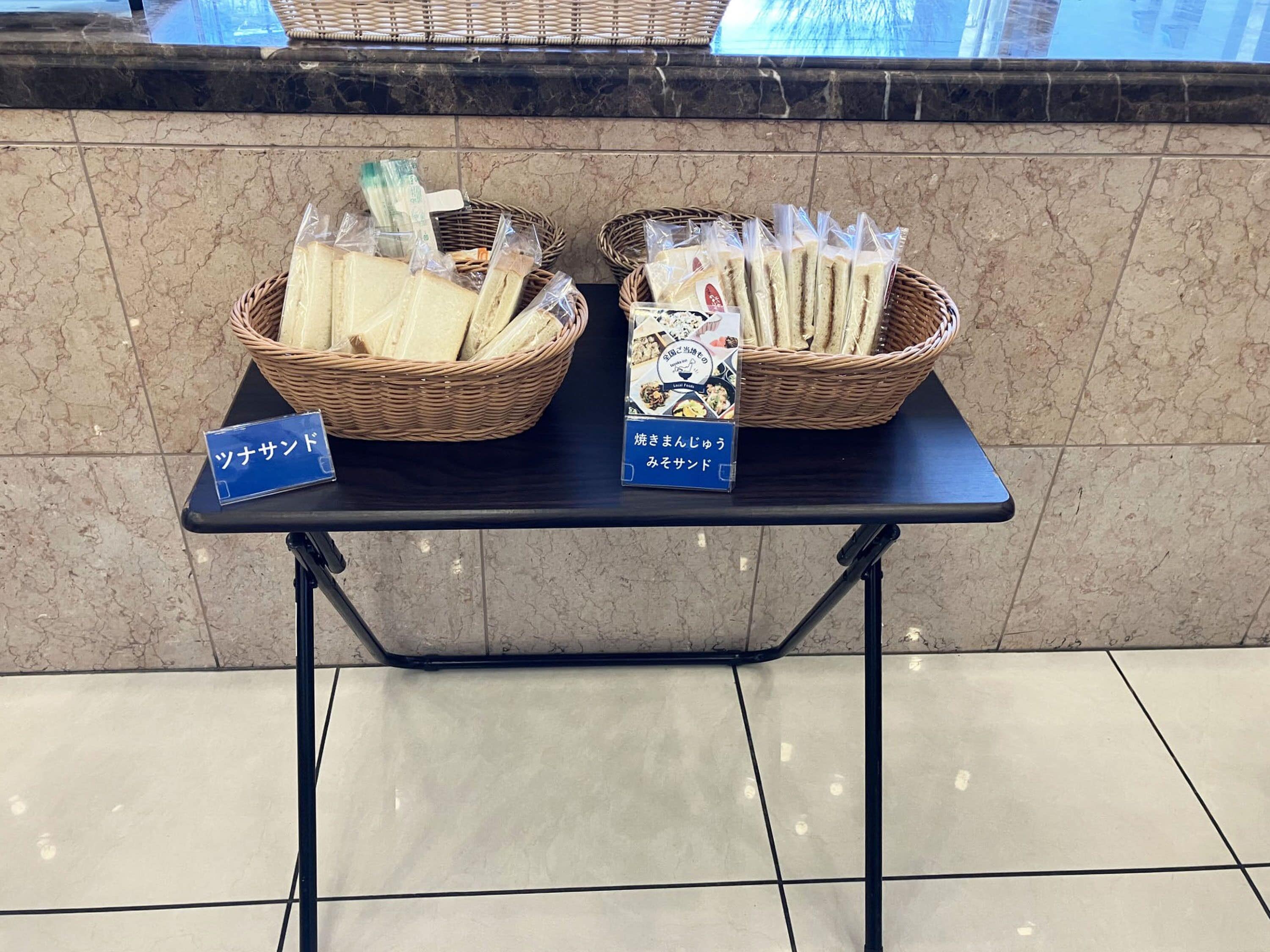 Uma mesa com duas cestas de pão e dois sinais azuis com texto em japonês.
