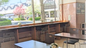 Um restaurante com vista para a rua, com cabines e mesas.