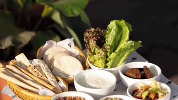 Uma mesa com diversos alimentos, incluindo pão, saladas e patês.
