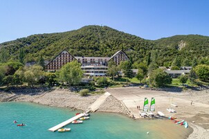 Hotel à beira-mar com vários edifícios, um cais e barcos.