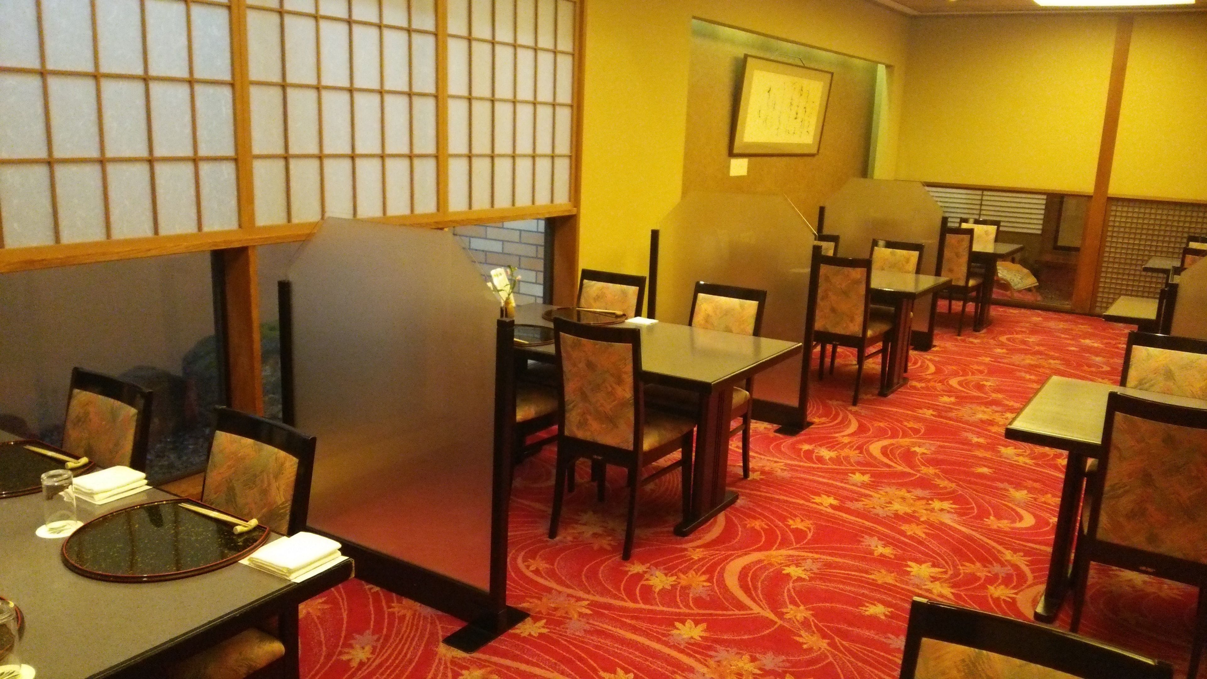 Um restaurante com tapete vermelho, mesas e cadeiras de madeira.