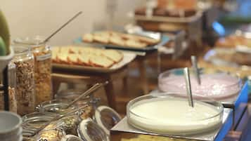 Buffet com diversos alimentos, incluindo uma tigela de sopa, potes de granola e uma bandeja de pão.