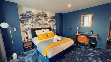 Quarto com cama, mesa de cabeceira, cadeira e escrivaninha.