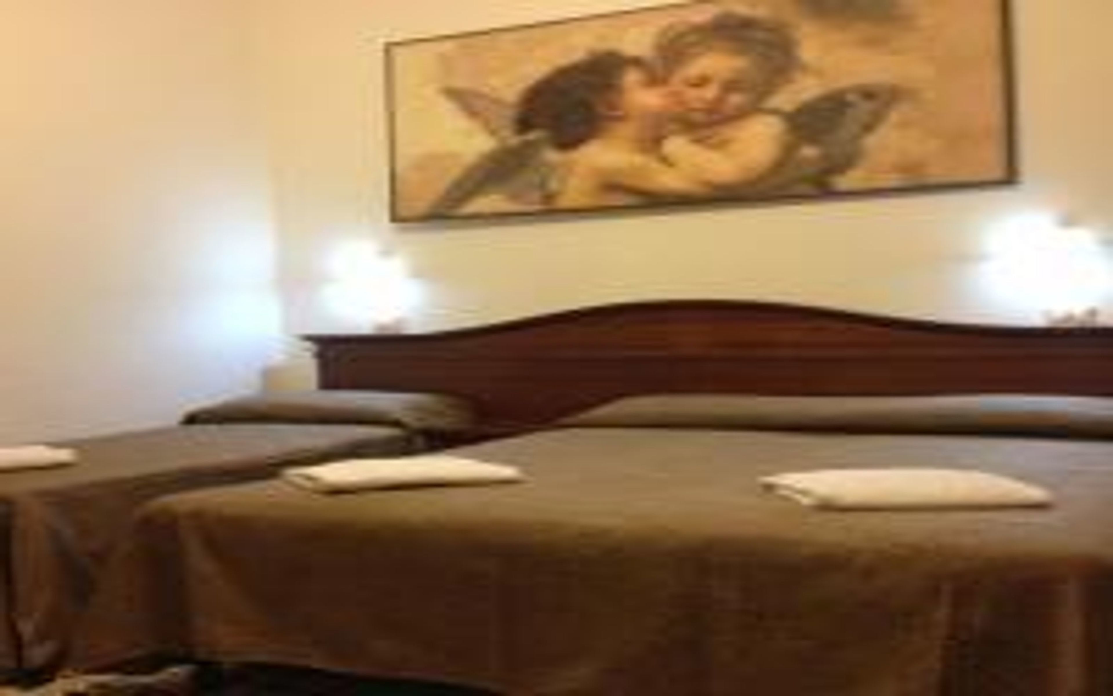 Quarto de hotel com duas camas de solteiro, cada uma com uma almofada e uma toalha dobrada.