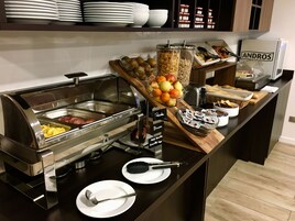 Uma mesa de buffet com diversos alimentos e acompanhamentos.