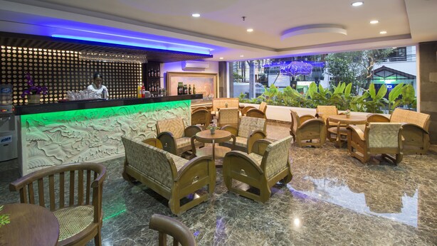 Um hall com área de bar, assentos e vista para o exterior.