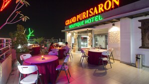 Exterior do Grand Purisaron Boutique Hotel, com área de estar externa e árvore de Natal.