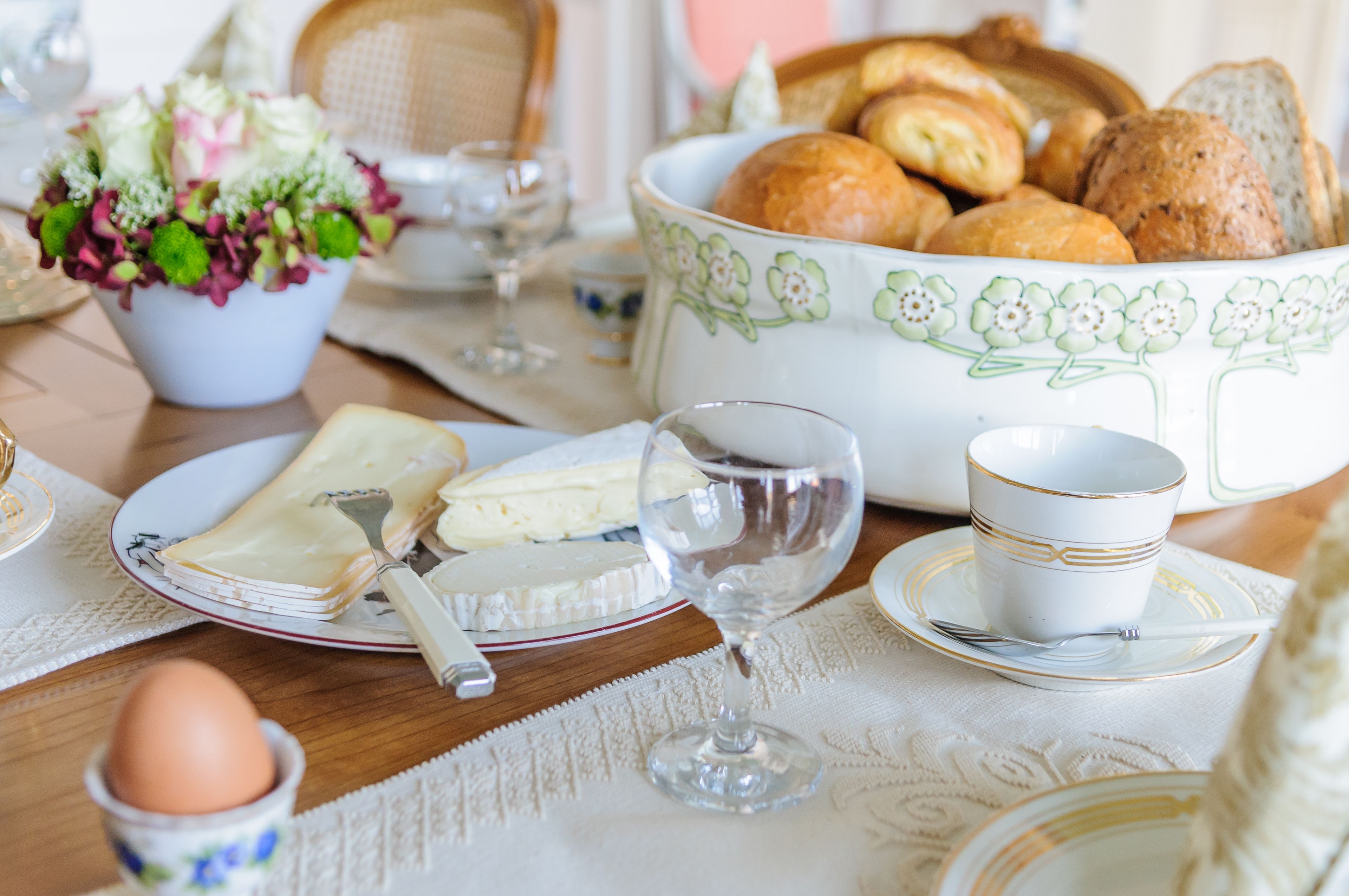 Mesa com uma tigela de pastelaria, queijo e uma chávena.
