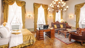 Quarto com cama, escrivaninha, sofá e lustre.