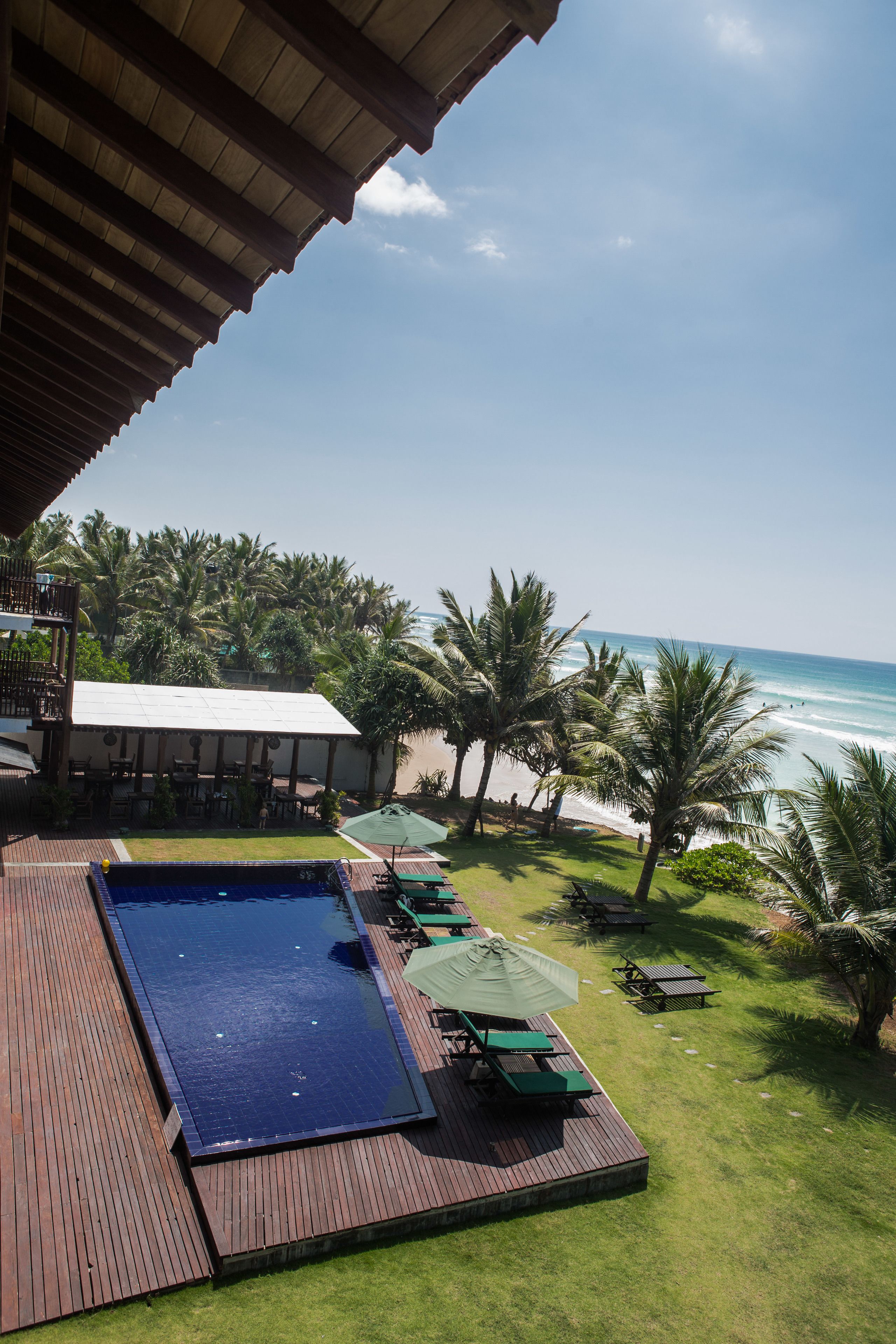 Área da piscina com vista para a praia e o oceano.