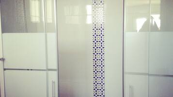 Quarto com porta deslizante, porta-toalhas e janela com persianas.