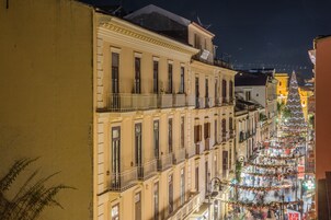 Um edifício com várias andares, varandas e um pinheiro de Natal enfeitado com luzes.