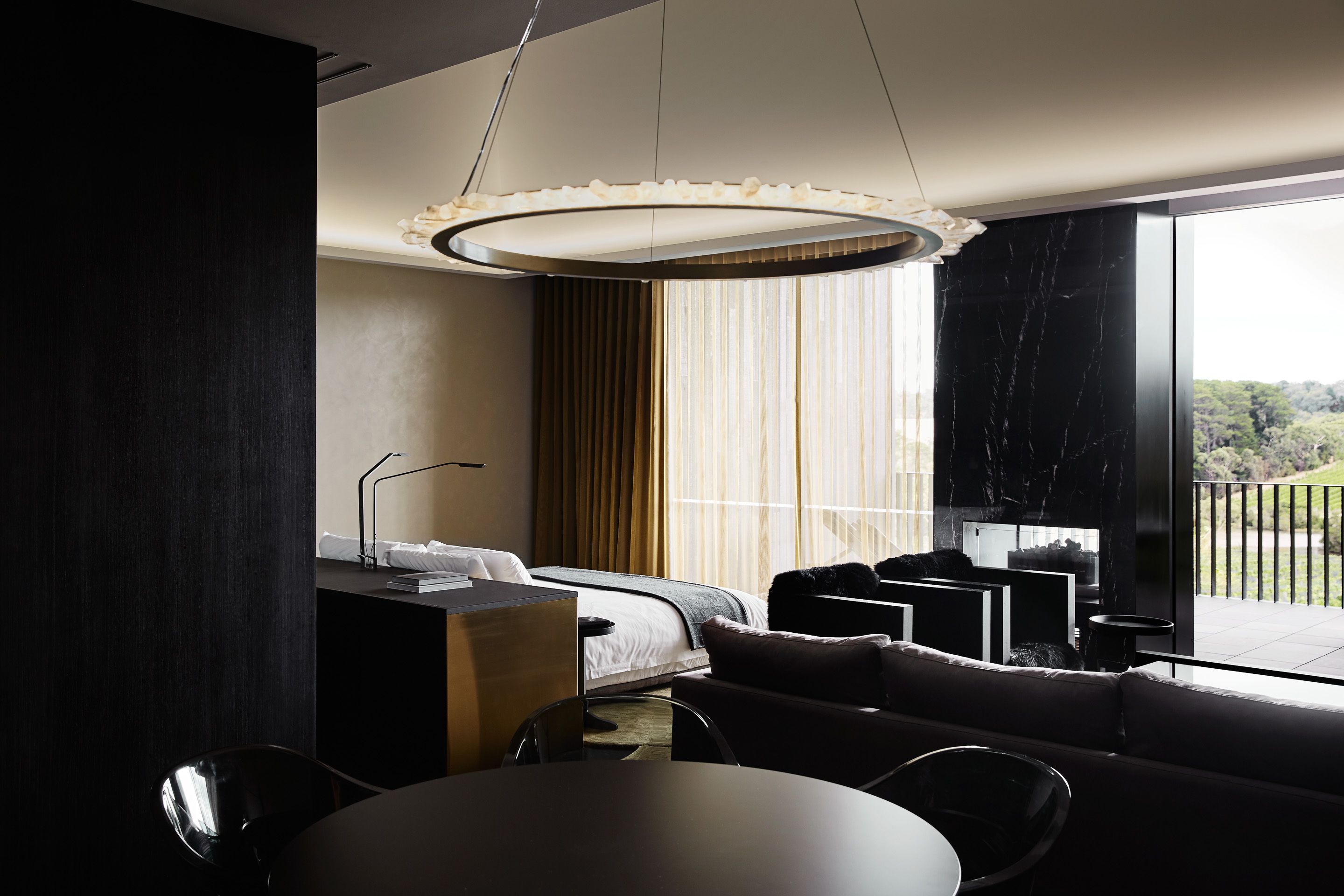 Quarto de hotel moderno com cama, escrivaninha, sofá e varanda com vista.