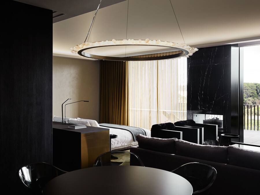 Quarto de hotel moderno com cama, escrivaninha, sofá e varanda com vista.