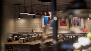 Uma cozinha moderna com iluminação pendente, painel de azulejos e uma ilha central.