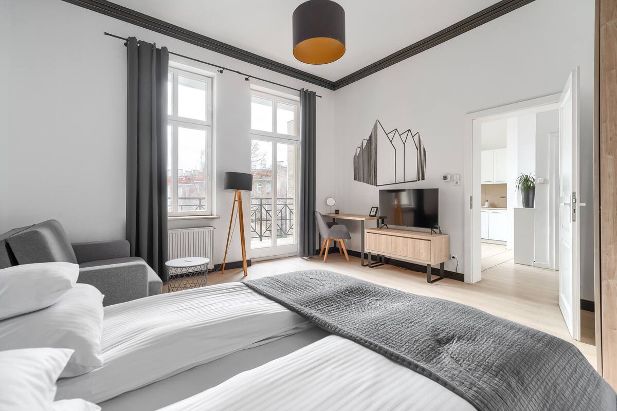Um quarto moderno com uma cama grande, uma escrivaninha e uma televisão.