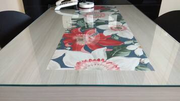 Uma mesa de conferência com toalha de mesa florida, um telefone e um filtro de linha.